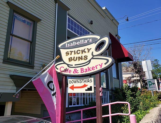 That cheerful sign pointing downstairs is your treasure map to carb-loaded happiness and the best cinnamon rolls in Maine.