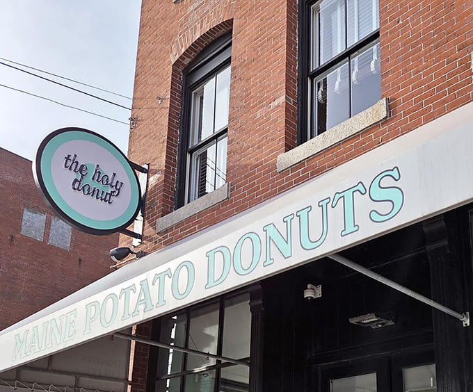 That mint green sign beckons like a lighthouse for the carb-hungry, promising salvation in circular, fried form.