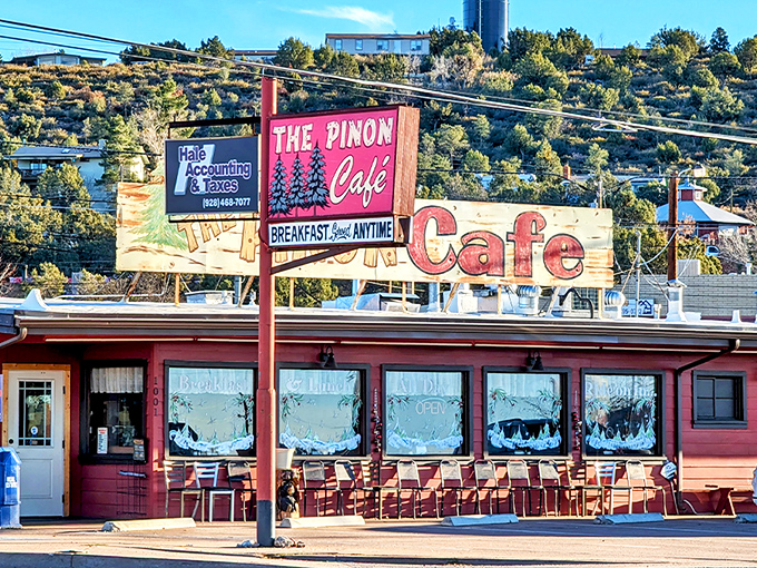 The iconic red exterior of The Pinon Cafe welcomes hungry travelers with its vintage charm and promise of breakfast anytime.