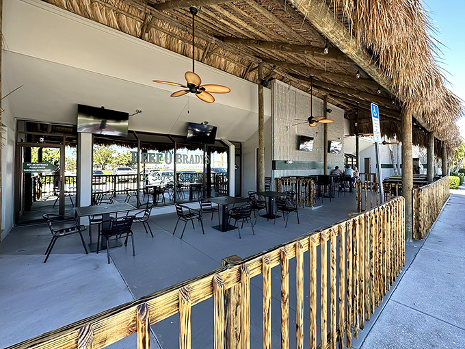 Tropical vibes meet sports bar comfort at Beef 'O' Brady's outdoor patio, where thatched roofs and ceiling fans create the perfect Florida dining atmosphere.