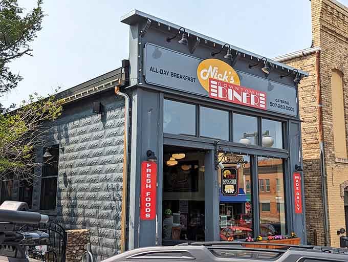 The cheerful exterior of Nick's Downtown Diner beckons hungry travelers like a beacon of breakfast hope in downtown Cannon Falls.