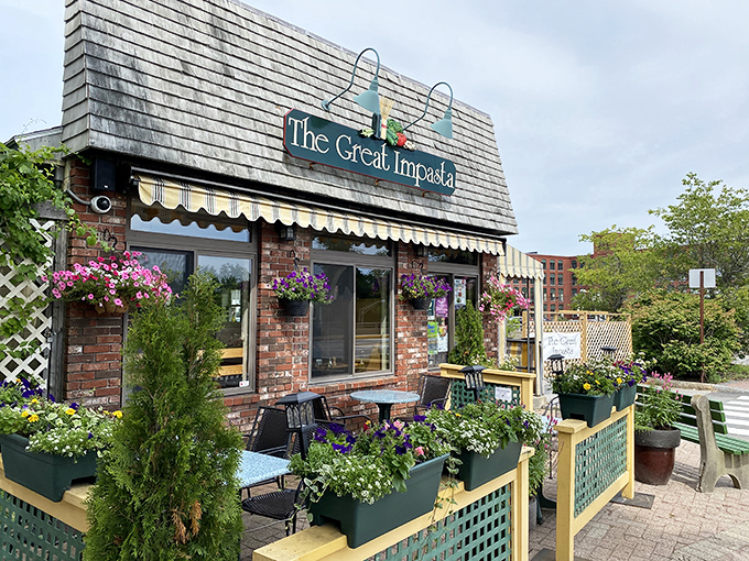 The charming brick exterior of The Great Impasta welcomes visitors with colorful hanging flower baskets and a cozy outdoor seating area.