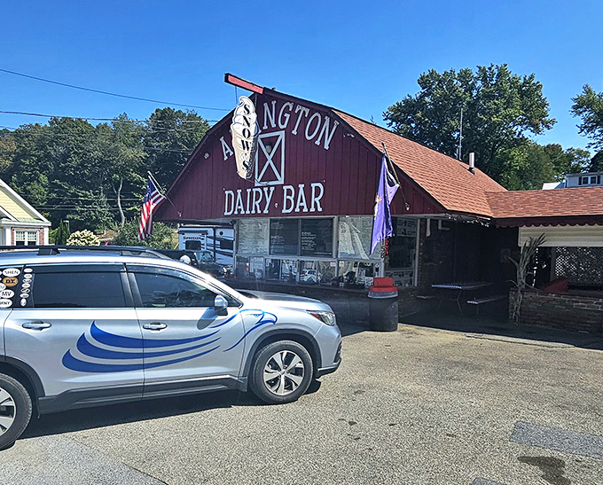 The iconic red barn exterior of Arlington Dairy Bar stands proudly against Vermont's blue sky, a beacon of frozen delight for generations of ice cream lovers.