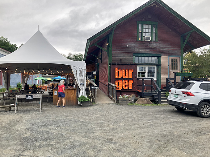 The weathered red barn with its bold "burger" sign promises authenticity without pretension &ndash; Vermont's culinary soul in architectural form.