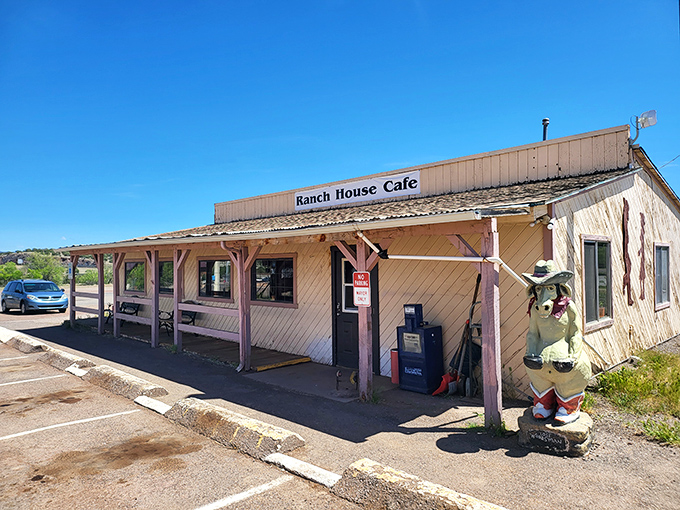 The unassuming exterior of Ranch House Cafe hides a burger paradise within, complete with a welcoming porch and quirky cowboy greeter.
