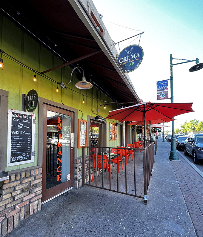 The vibrant lime-green exterior of Crema beckons hungry visitors with its charming brick accents and inviting outdoor seating area.