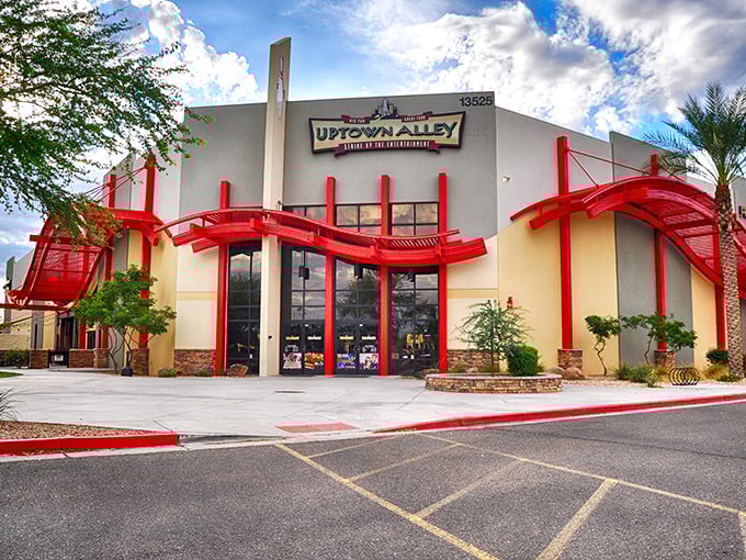 Uptown Alley's striking exterior welcomes fun-seekers with its bold red architectural elements &ndash; a neon-lit oasis in the Arizona desert.