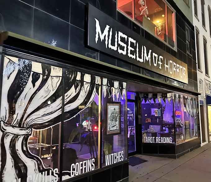 The ominous storefront of Monroe's Museum of Horror beckons with purple lighting and promises of macabre treasures within.