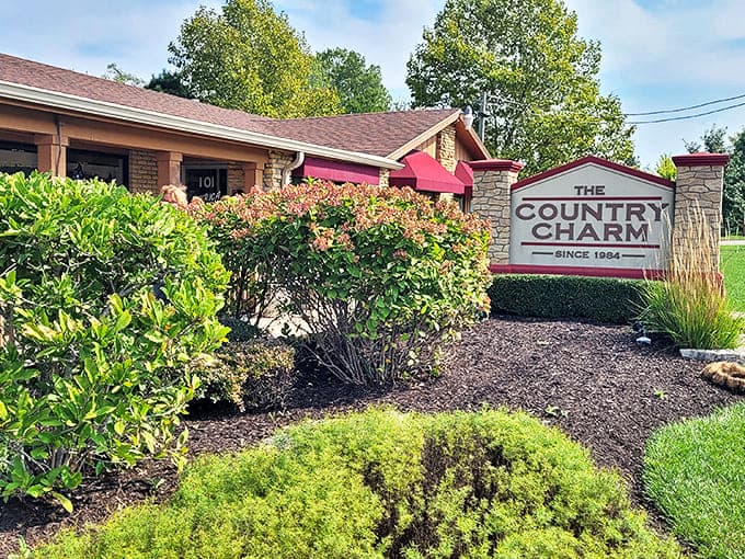 The welcoming exterior of Country Charm Restaurant, where burgundy awnings and stone pillars have been inviting hungry diners since 1984.