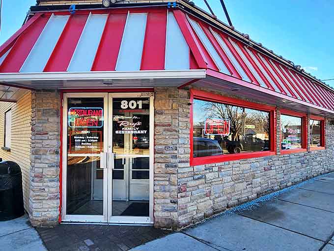 The iconic red-striped awning of Ray's Family Restaurant beckons hungry diners like a breakfast lighthouse on Elgin's busy street.