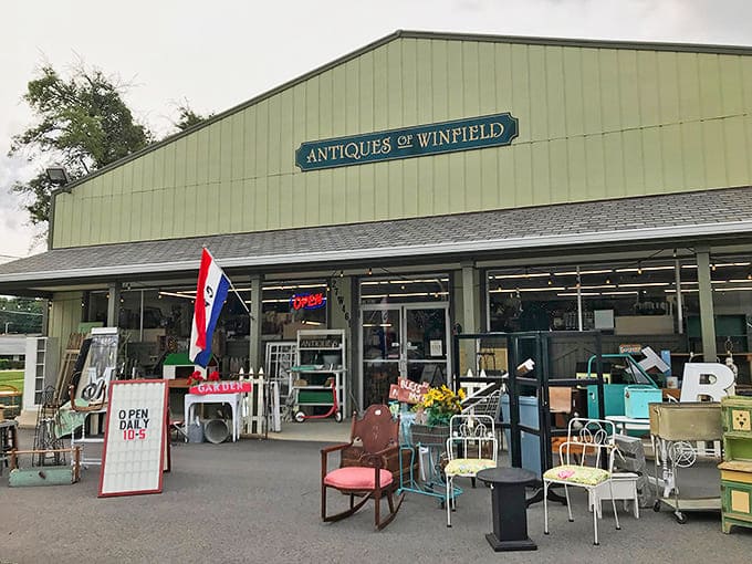 The mint-green exterior of Antiques of Winfield stands like a time portal, American flag waving a welcome to treasure hunters and nostalgia seekers.