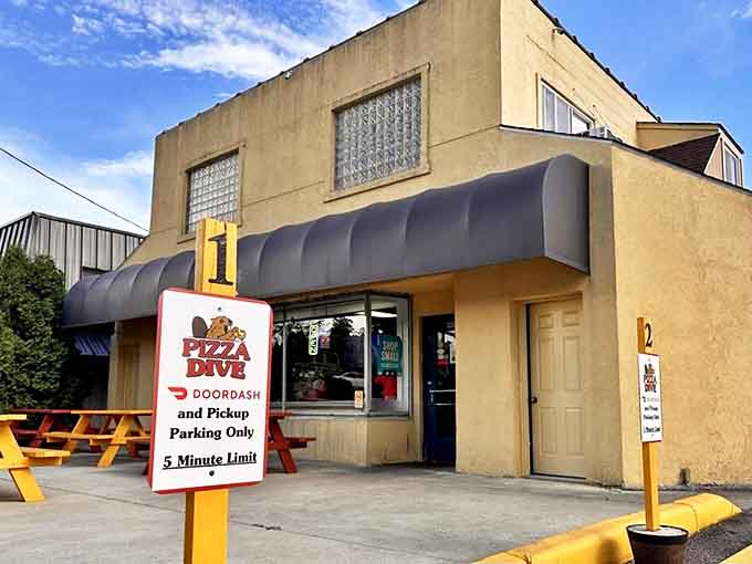 The red door and picnic table outside signal the kind of unpretentious, welcoming vibe that defines true neighborhood eateries.