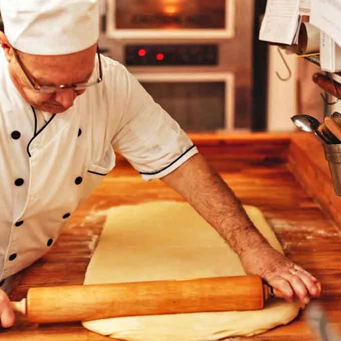 Flour-dusted hands work with practiced precision &ndash; decades of baking wisdom go into every Bunde's creation.