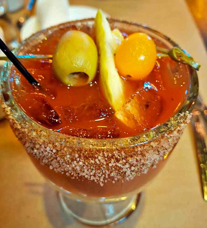 The Bloody Mary arrives like a meal in itself, sporting a spice-crusted rim and garden of garnishes that make Sunday brunch feel like a celebration.