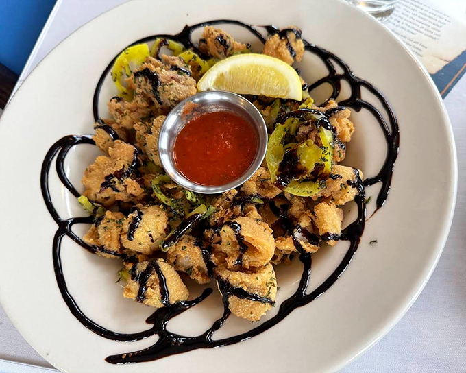 Calamari artfully arranged with a balsamic drizzle &ndash; crispy, tender, and miles from the rubbery rings lesser restaurants serve.