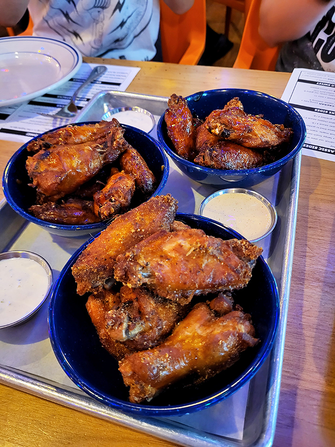 These aren't just wings – they're smoke-kissed, sauce-slathered flavor bombs served in cobalt blue bowls of happiness.