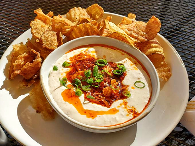 Crispy homemade chips surrounding a cloud of dip, topped with vibrant scallions. Sharing optional but not recommended.