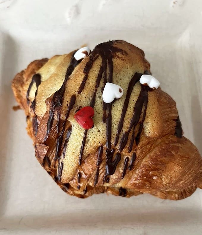 This chocolate-drizzled croissant with its festive decorations isn't just breakfast &ndash; it's a celebration on a plate, no special occasion required.