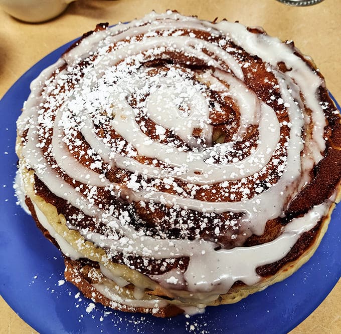 Cinnamon roll pancakes with swirls of cinnamon and cream cheese icing&mdash;proof that someone in the kitchen is thinking about your happiness on a profound level.