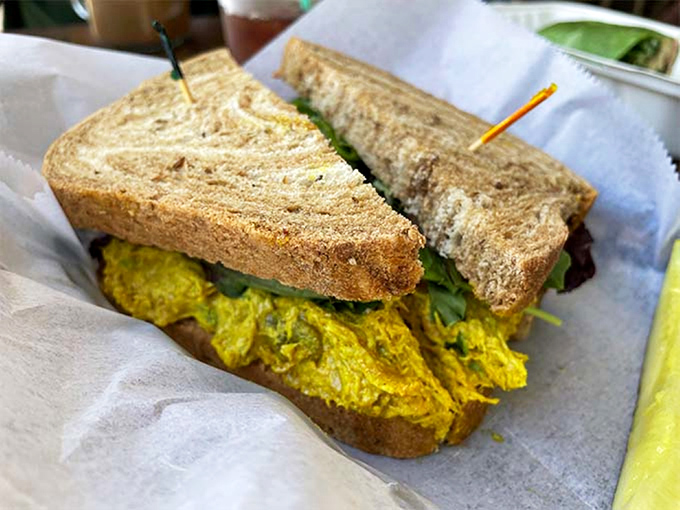 Curry chicken salad sandwich that brings global flavors to small-town Vermont. That vibrant yellow against hearty grain bread? Food poetry.
