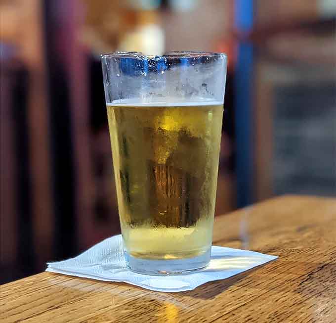 A perfectly poured beer catches the light, promising refreshment to wash down all those delicious decisions you're about to make.
