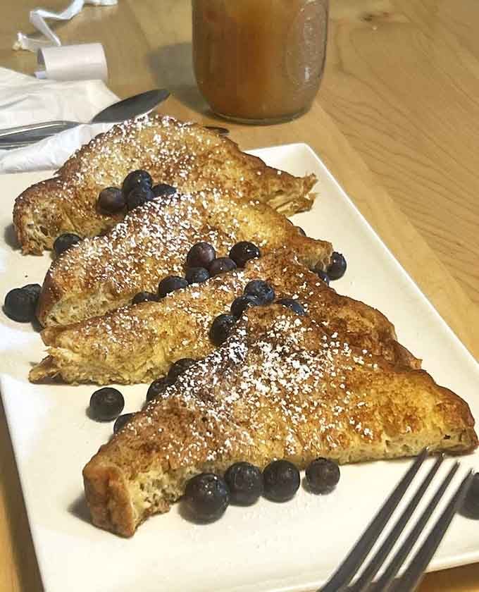 French Toast: Bread transformed into morning dessert, dusted with powdered sugar like fresh snow on a delicious mountain range.