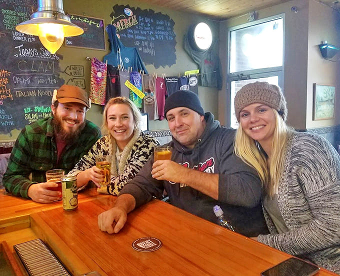 Happy diners enjoying craft beers at wooden tables capture the tavern's welcoming vibe that keeps locals and visitors coming back.
