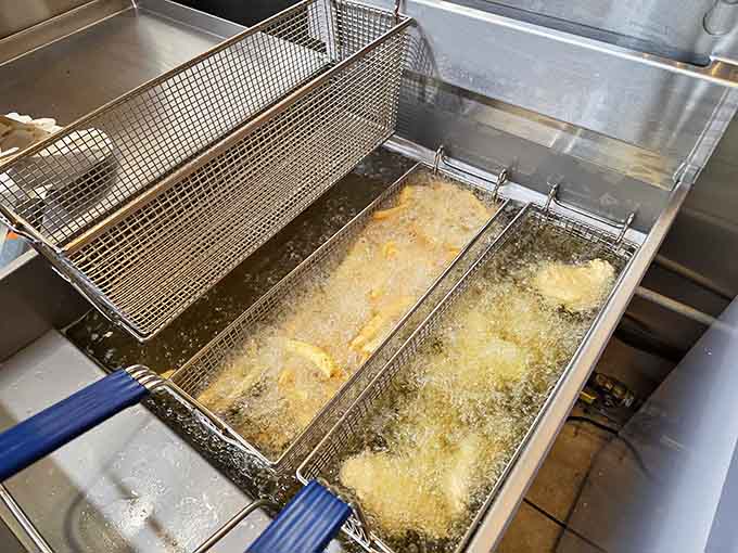 The magic happens right here in these fryers, where fresh seafood transforms into golden, crispy perfection that keeps people coming back.
