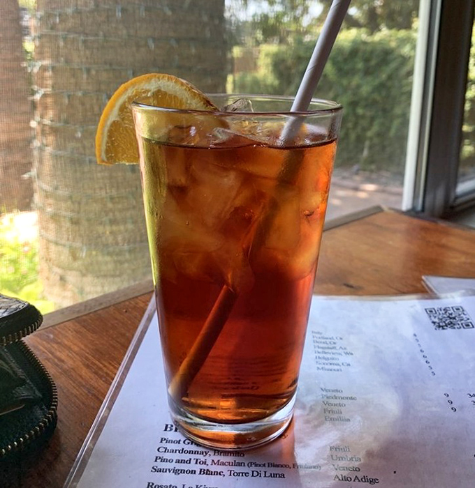 Iced Tea: A refreshing amber elixir served with a slice of orange &ndash; the perfect companion for Phoenix's sunshine and Cibo's flavorful Italian fare.