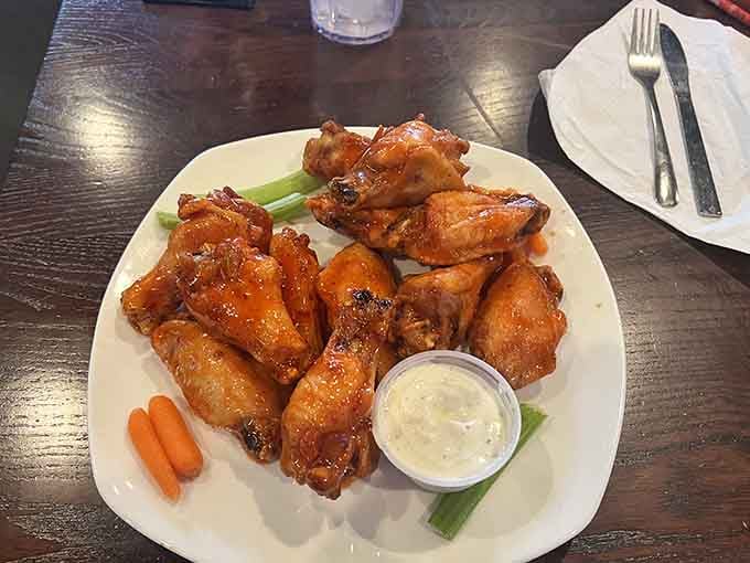 Wings glazed in sauce arrive with classic accompaniments, offering just the right amount of heat and flavor to satisfy any craving.
