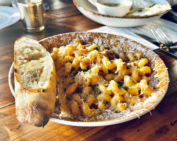 Vin Rose Pasta arrives looking almost too pretty to eat, though that hesitation typically lasts about three seconds before forks start flying.