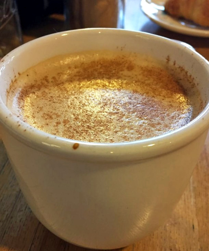 A comforting ceramic mug cradles this cinnamon-dusted masterpiece &ndash; the perfect companion for bagel contemplation.