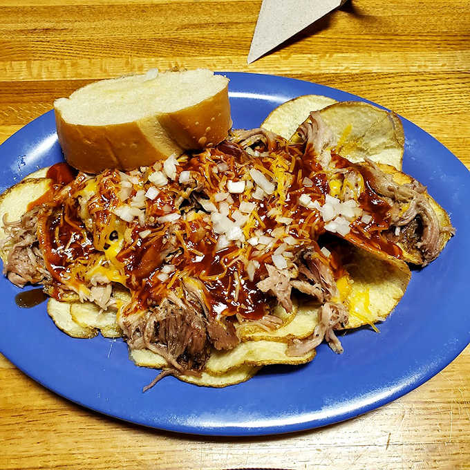 BBQ architecture at its finest &ndash; pulled pork piled high on a waffle with cheese, onions, and sauce creating a savory skyscraper of flavor.