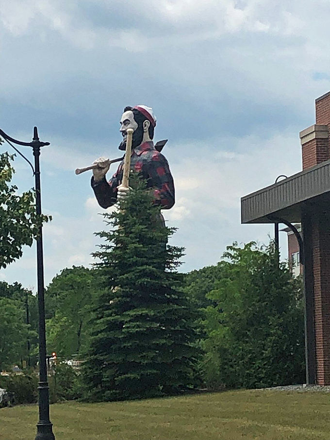 Nestled among trees that seem ironically small by comparison, Paul stands guard like a sentinel of American mythology against the modern backdrop.