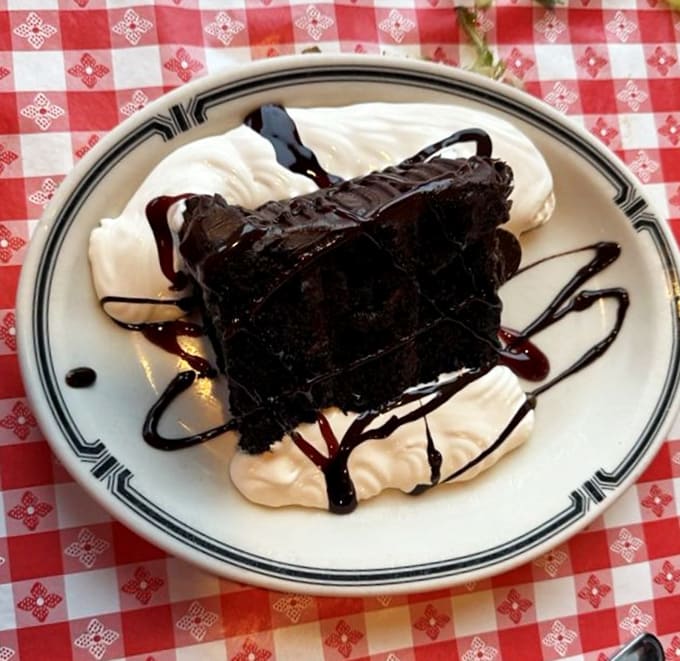 That towering chocolate cake is pure indulgence, with layers of moist cake and rich frosting that make elastic waistbands a smart fashion choice.