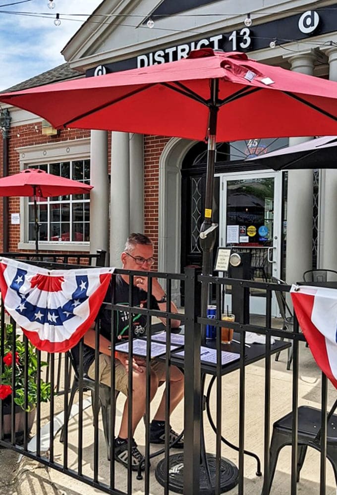Red umbrellas shade the inviting outdoor seating area, where patriotic bunting adds hometown pride to this perfect people-watching perch.