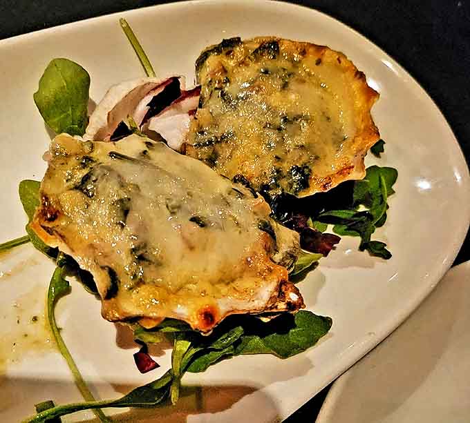 Oysters Rockefeller arrive like jewels on a silver platter, their spinach-cheese topping bubbling hot while hiding the briny treasures beneath&mdash;oceanic indulgence at its finest.