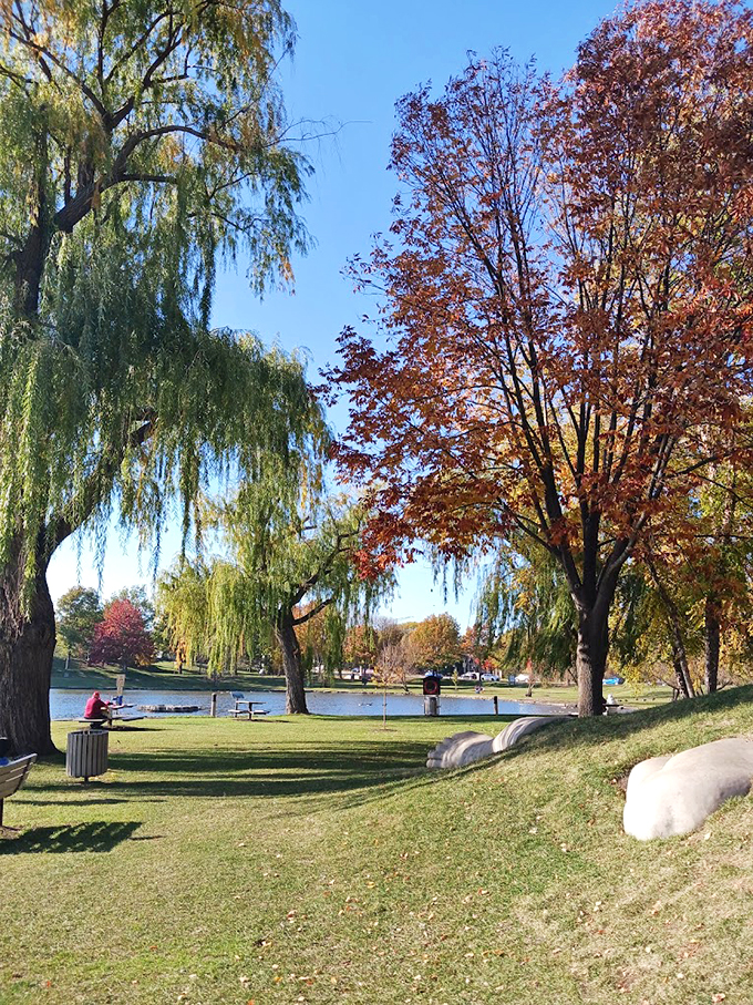 Weeping willows frame this peaceful scene, where benches invite visitors to pause and contemplate the surrounding beauty.