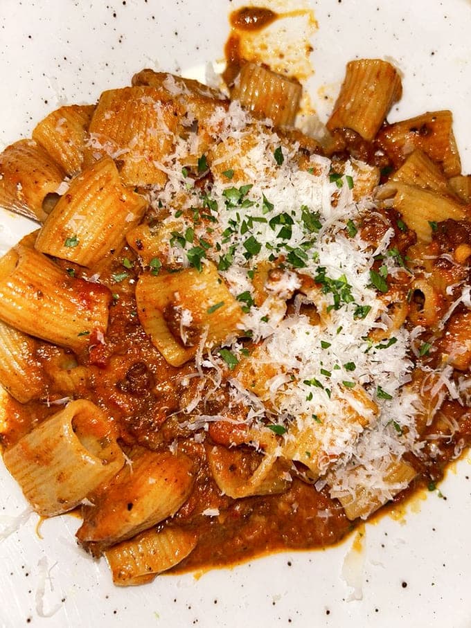 Rigatoni Bolognese delivers comfort in tubular form, each piece catching sauce like it was designed for exactly that.
