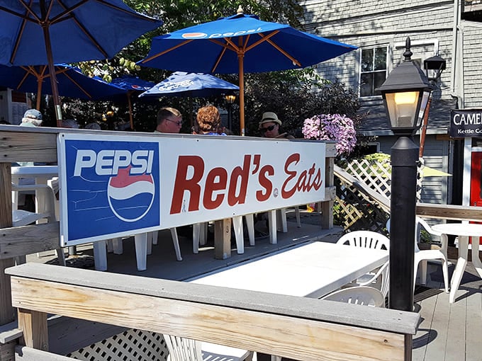 Outdoor seating with blue umbrellas and white tables creates the perfect spot for demolishing lobster rolls and blueberry cakes with water views.