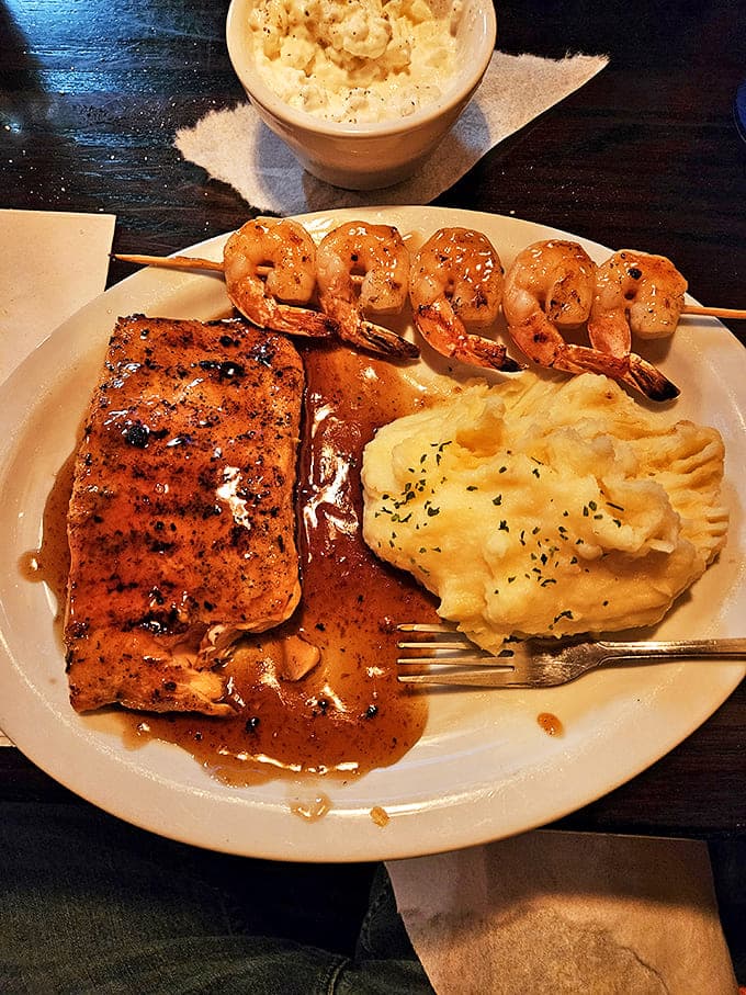 Ocean meets land in perfect harmony &ndash; tender salmon and succulent shrimp alongside creamy mashed potatoes that cloud-like consistency.