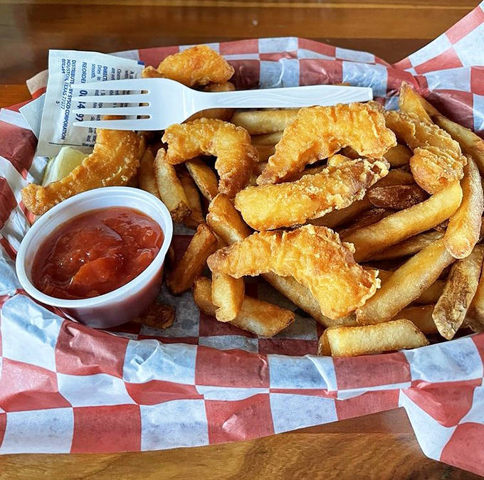 Golden-fried whitefish and crispy fries served in a classic red-checkered basket &ndash; unpretentious presentation for extraordinarily fresh seafood.