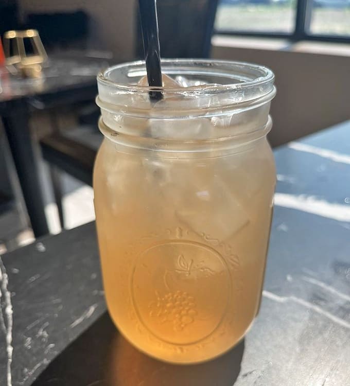 An Arnold Palmer served in a mason jar, because even the drinks here understand the assignment.