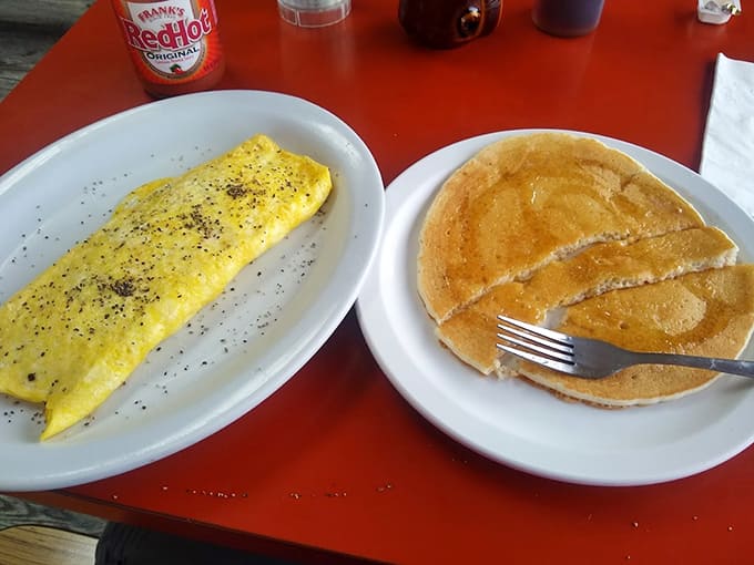 A fluffy omelet and stack of pancakes create the ultimate breakfast combo, offering both protein and carbs in quantities that defy moderation.