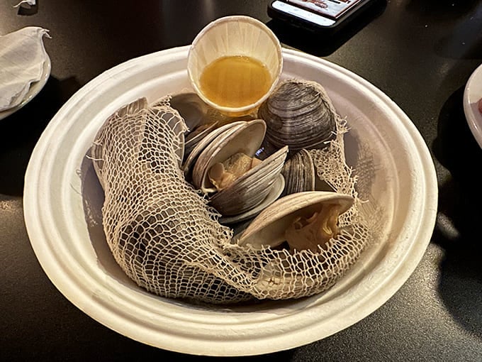Fresh clams nestled in their mesh cooking bag &ndash; oceanic treasures waiting to be dipped in melted butter and savored slowly.