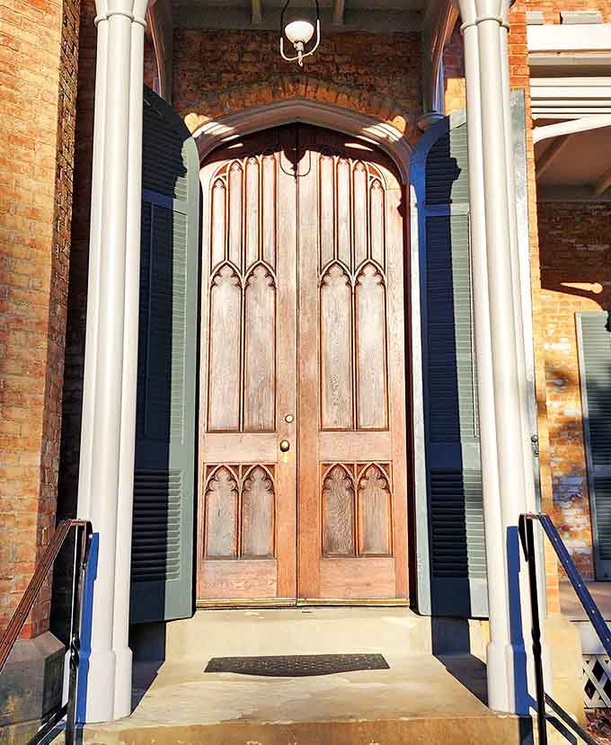 Gothic arches frame a doorway that has welcomed visitors for generations &ndash; an entrance that promises stories waiting just beyond the threshold.