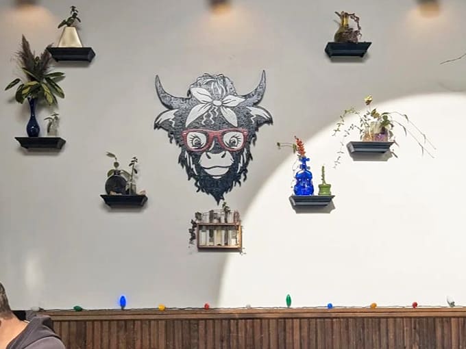 Quirky wall art featuring the signature cow watches over diners like a benevolent spirit animal of comfort food.