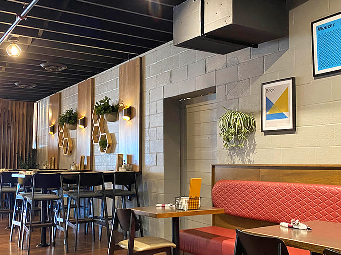 The dining room balances openness with coziness, featuring modern touches like geometric artwork and hanging plants that add life.