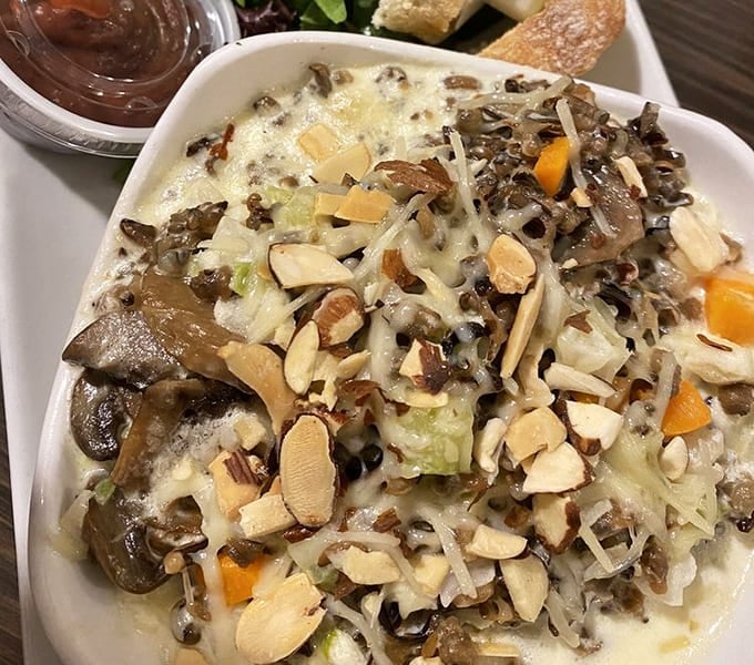 The wild rice hotdish gets a gourmet makeover, proving Minnesota's signature comfort food deserves respect and almonds.