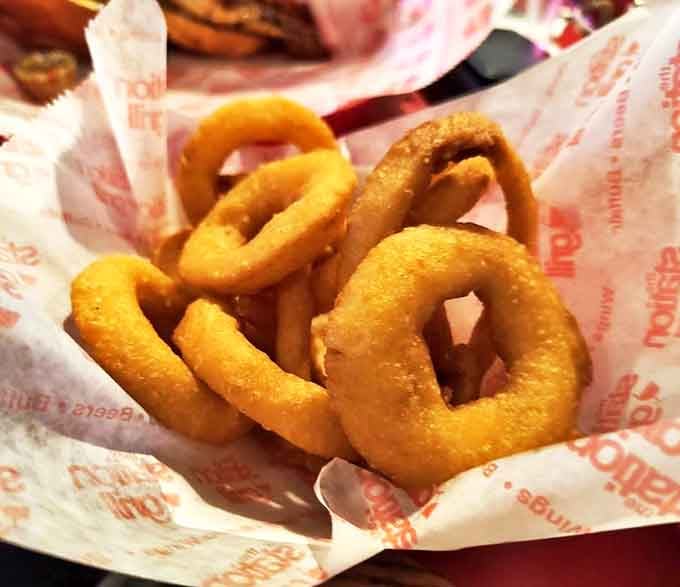 Golden onion rings achieve that ideal crispy-to-tender ratio, with breading that stays put and onions that don't slide out on first bite like some kind of vegetable escape artist.
